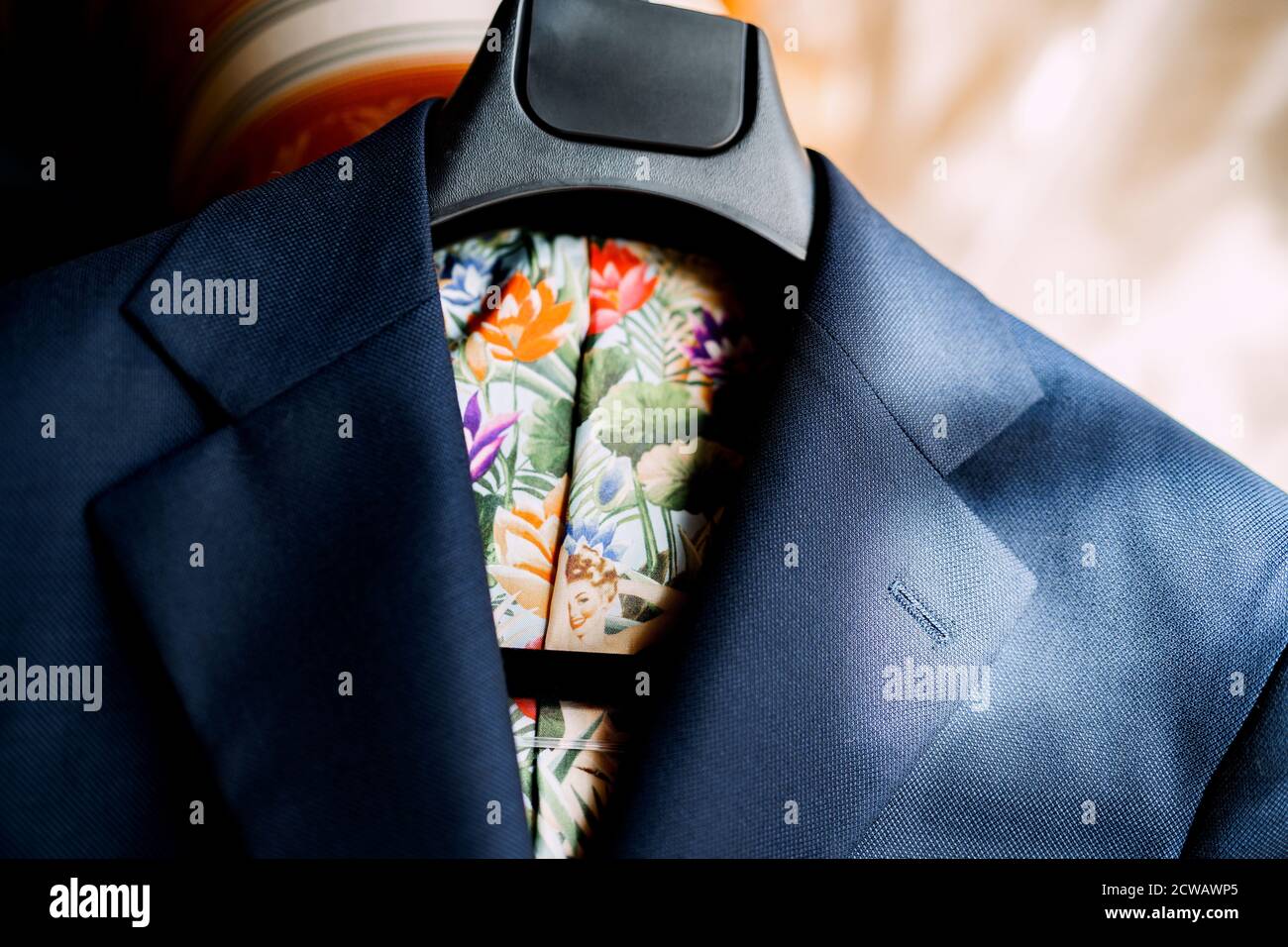 A bright blue jacket with a lining of colorful colors on a hanger Stock ...