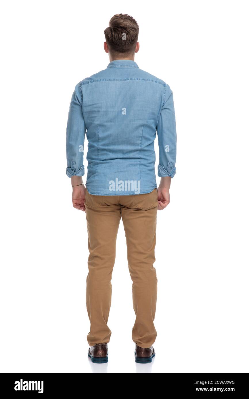 Rear view of a confident casual man standing on white studio background ...