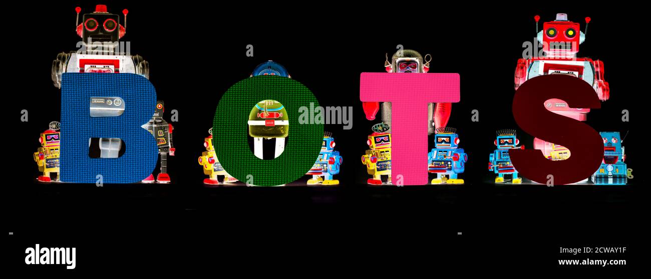 retro tin robot toys hold up the word BOTS isolated on black Stock ...