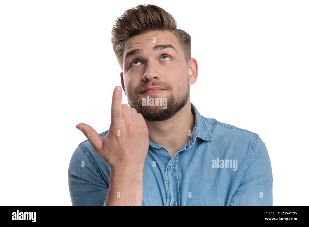 Confident casual man pointing upward while wearing shirt, standing on ...