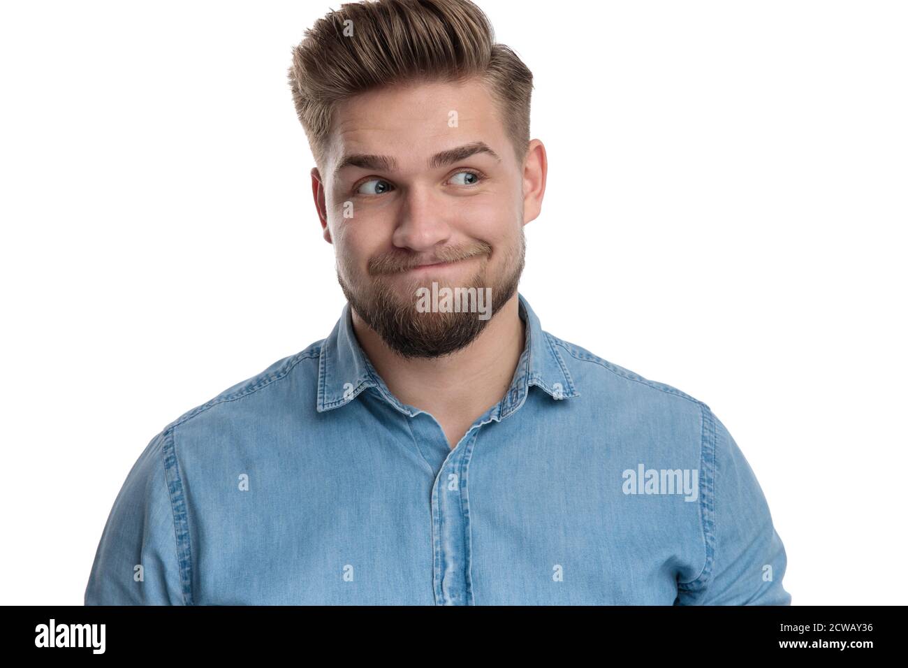 Young casual man making a funny face and looking away while wearing ...