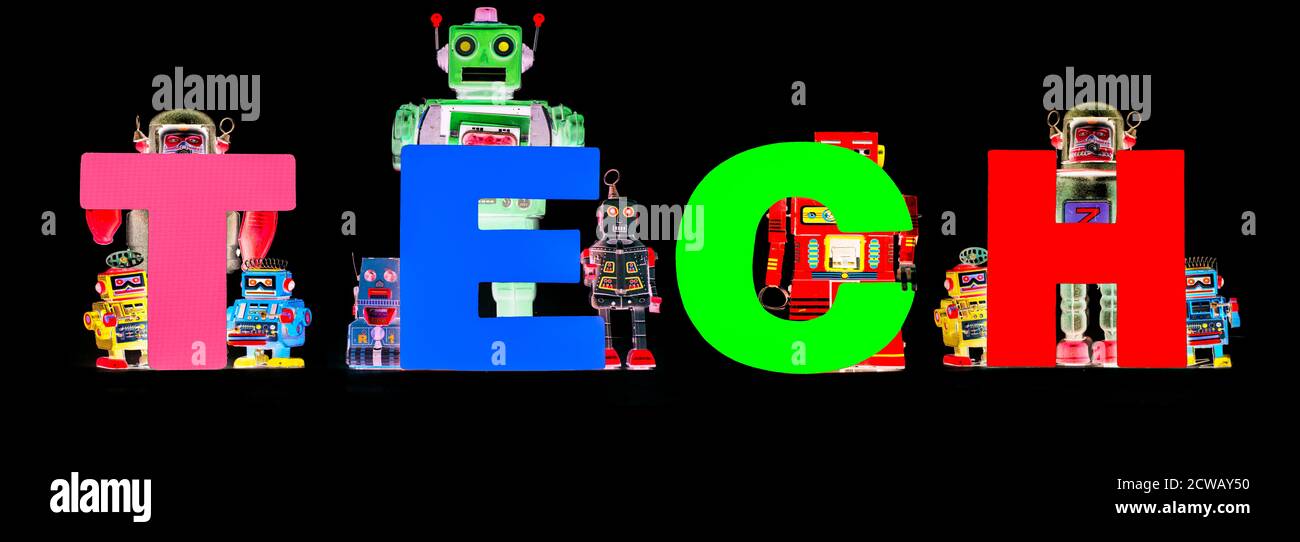 retro tin robot toys hold up the word TECH isolated on black Stock ...
