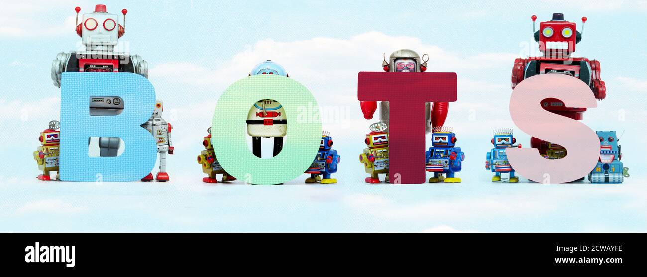 retro tin robot toys hold up the word BOTS cloud Stock Photo - Alamy