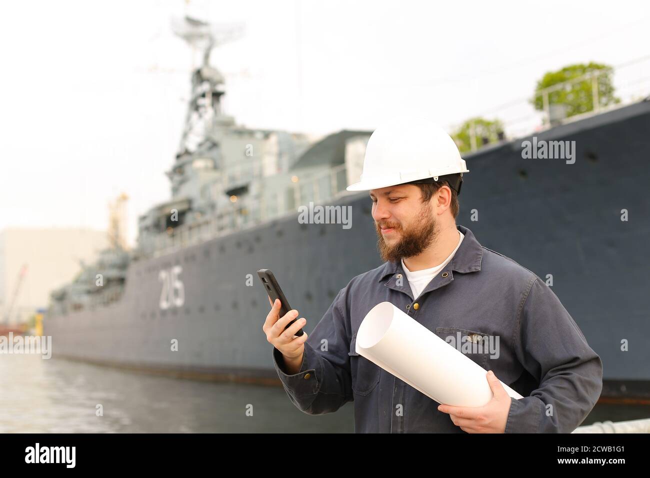 Marine engineer talking by VHF walkie talkie, holding papers near ...