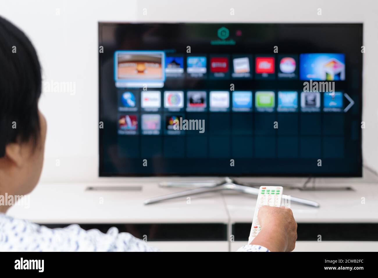 senior women hand hold remote control of TV box watching in the living ...