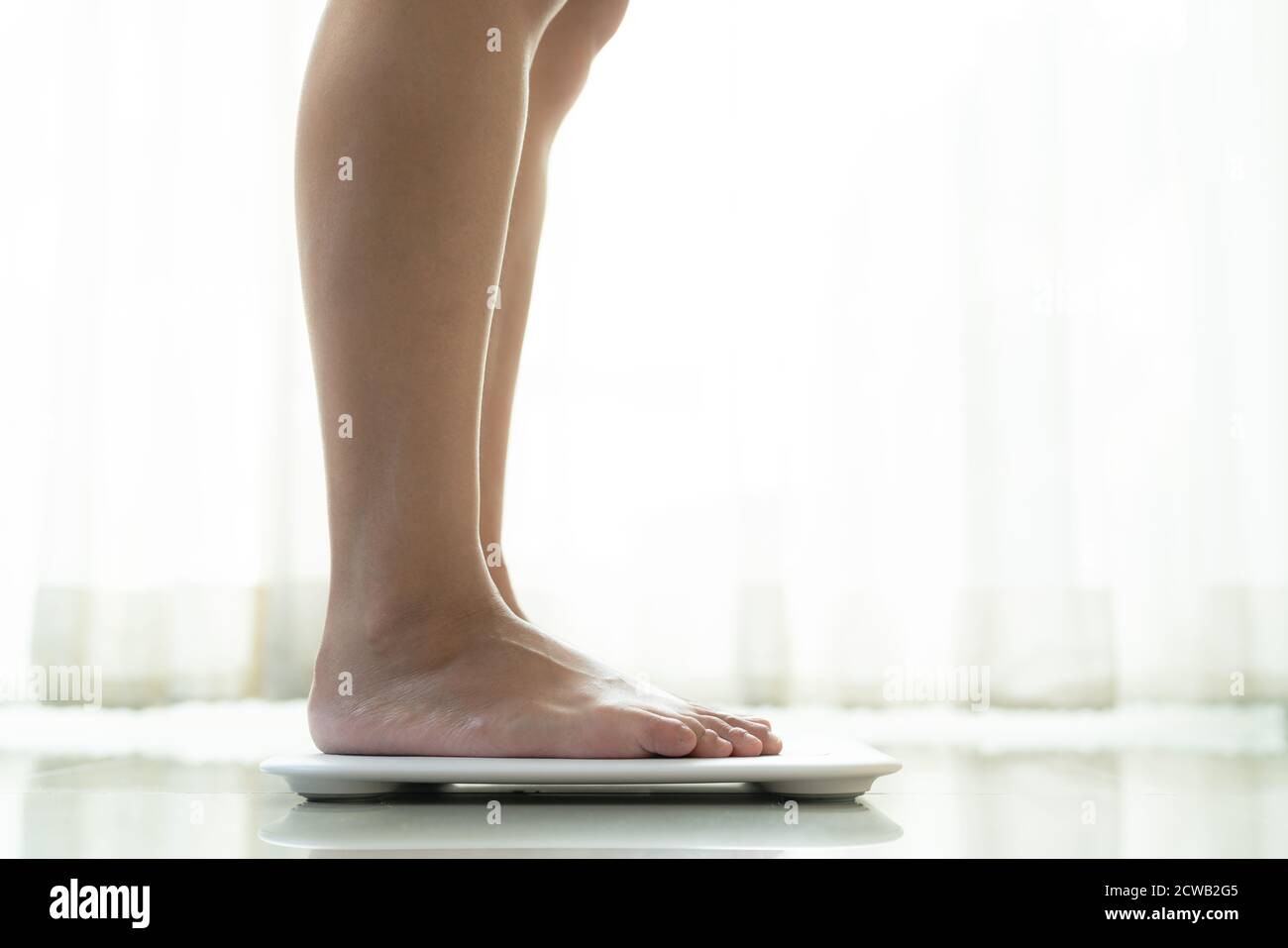 young woman standing on digital weight scale Stock Photo - Alamy
