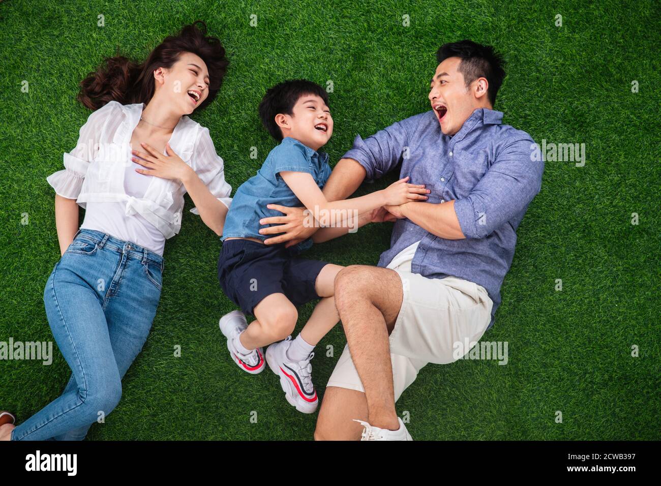 Play happy three lay on the grass Stock Photo - Alamy