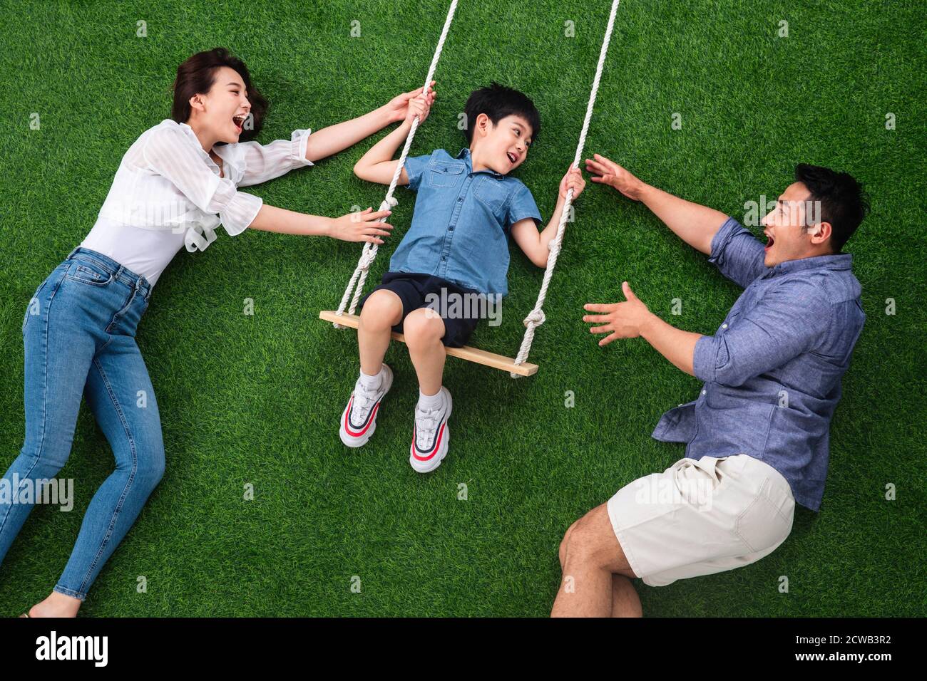 Happy three swing on the grass Stock Photo - Alamy