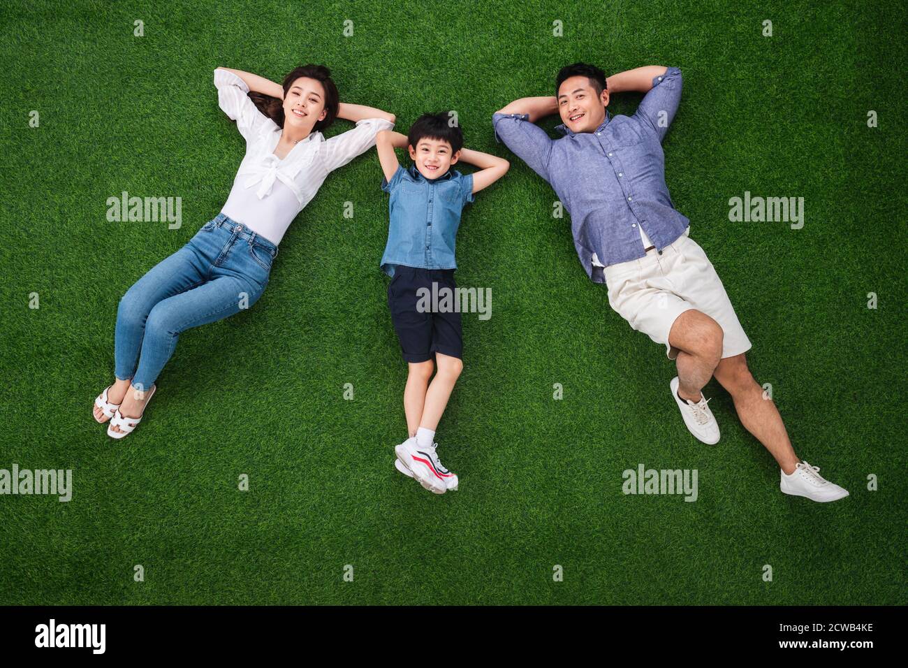 Happy three lay on the grass Stock Photo - Alamy