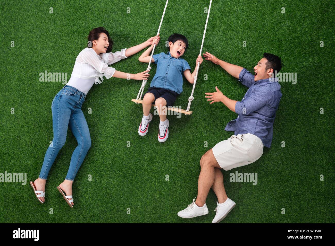 Happy three swing on the grass Stock Photo - Alamy