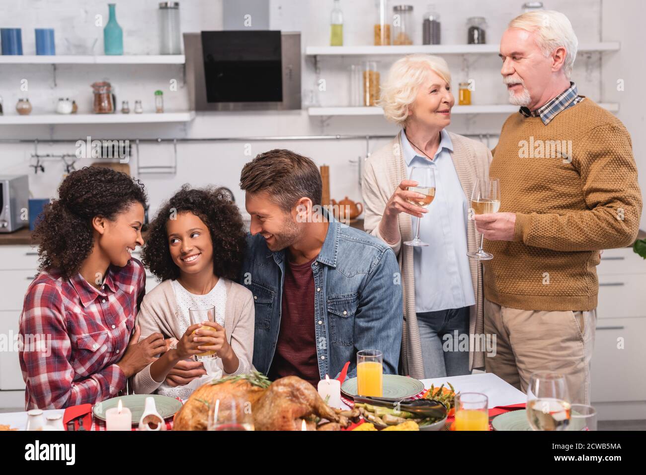 Selective focus of multicultural family with daughter talking during ...