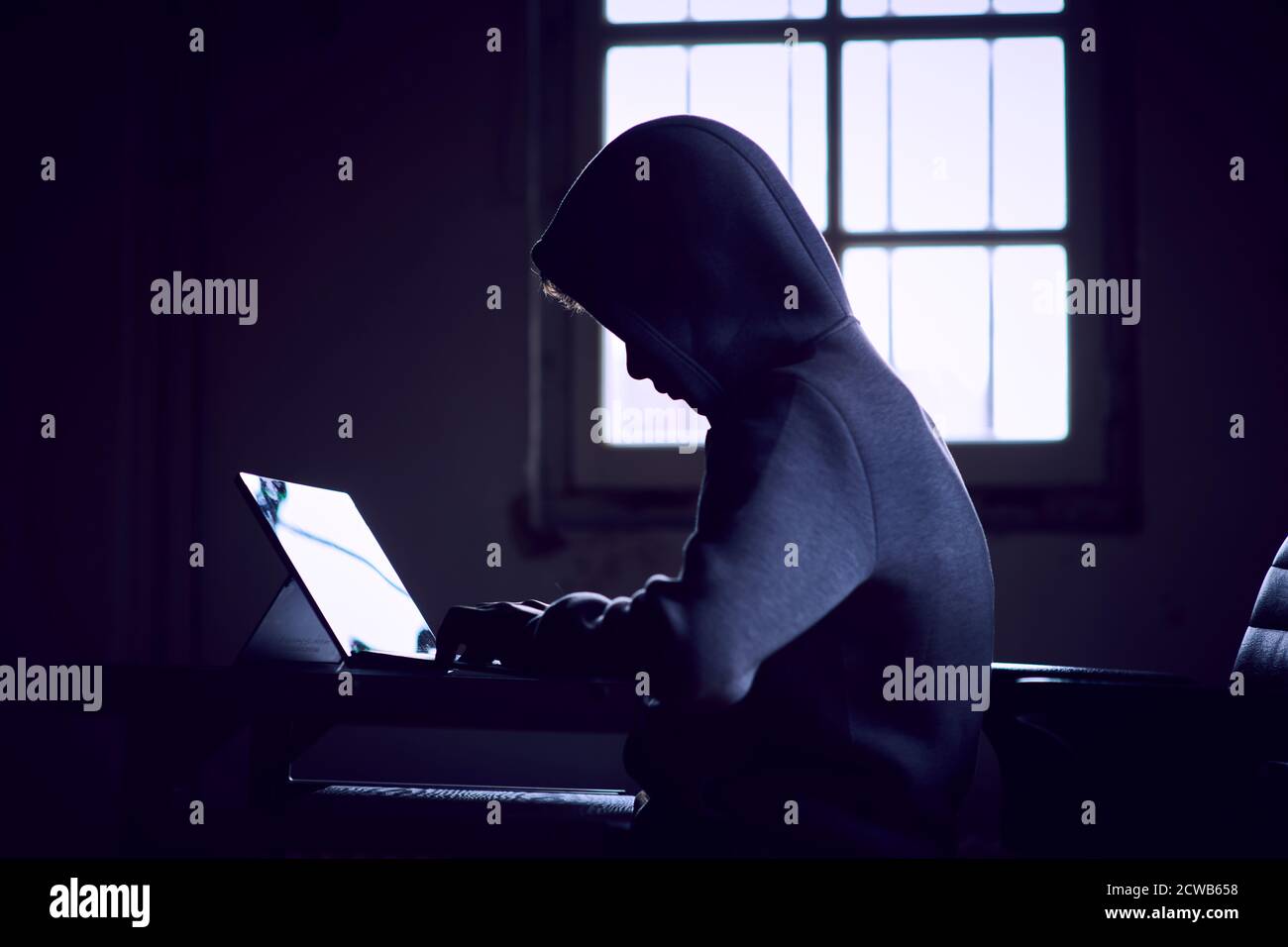 Computer hacker with hoodie behind his computer Stock Photo - Alamy