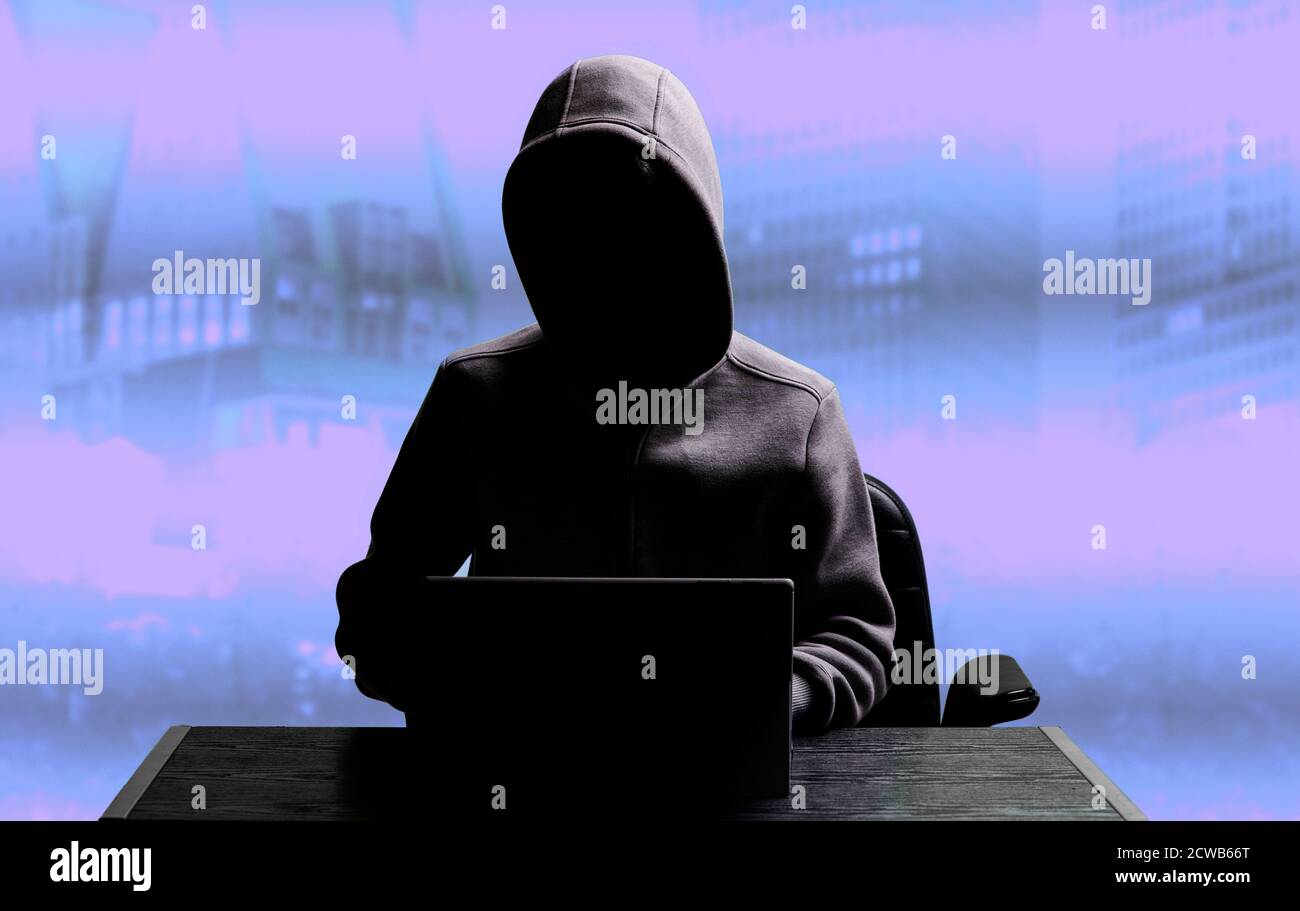Computer hacker with hoodie behind his computer Stock Photo - Alamy