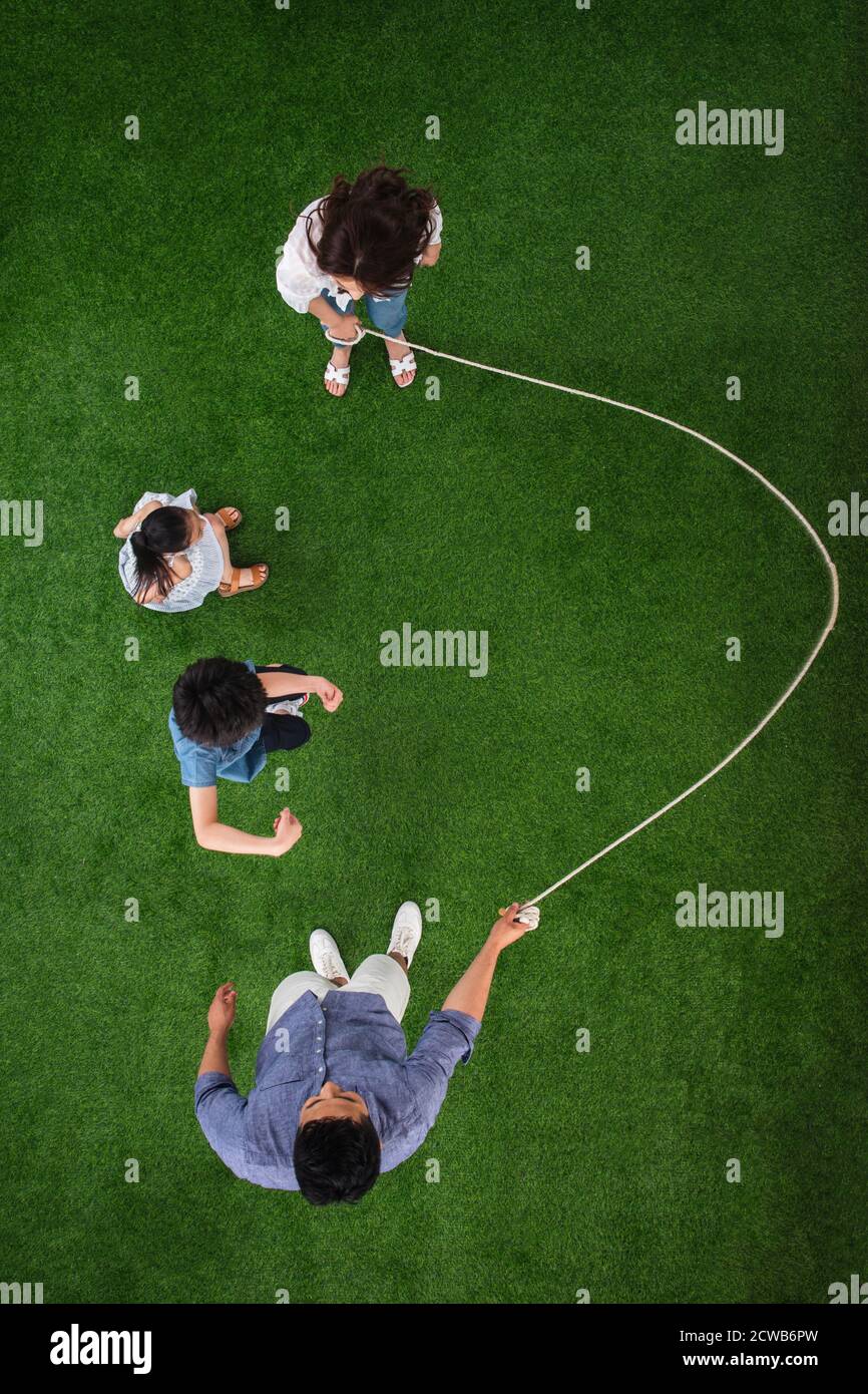 The happy family of four rope jumping on the grass Stock Photo - Alamy