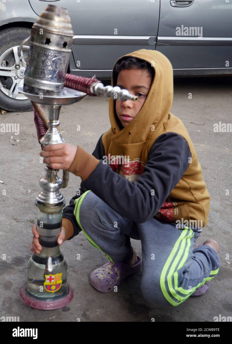 Photograph of a young Muslim boy holding a hookah Stock Photo - Alamy