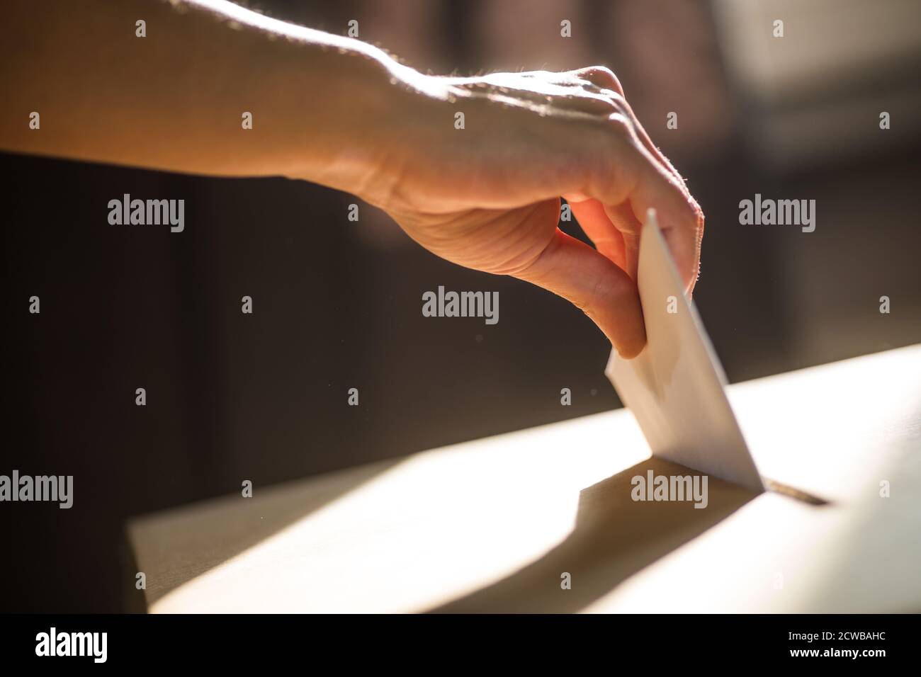 Conceptual image of a person voting, casting a ballot at a polling ...