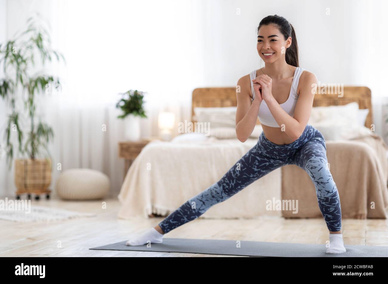 Home Aerobics. Sporty Asian Woman Doing Lunges Exercises On Mat In ...