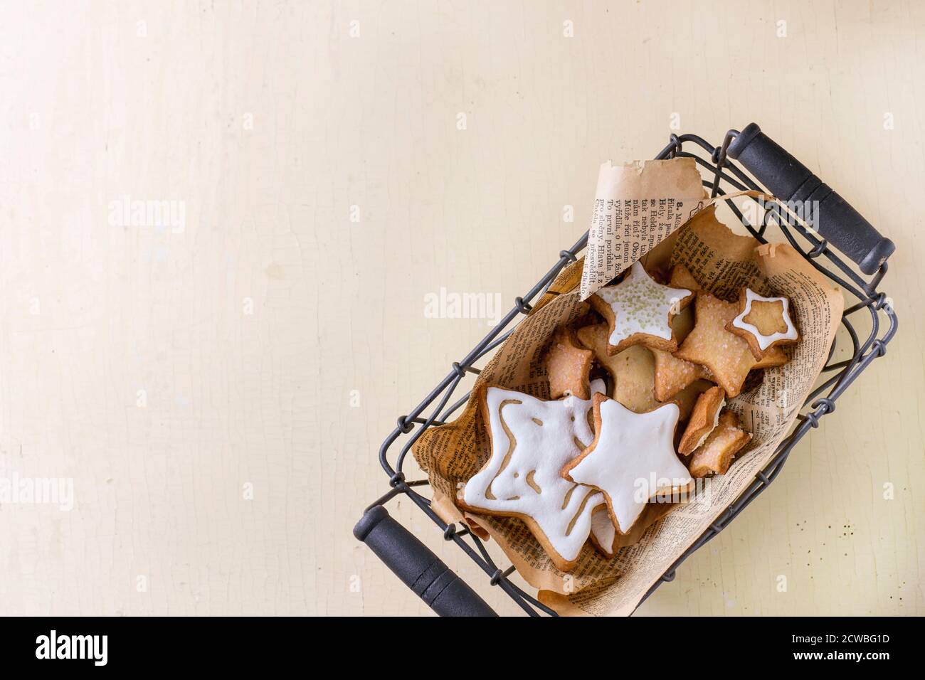 Glazed Christmas cookies as stars shapes in basket with old newspaper ...