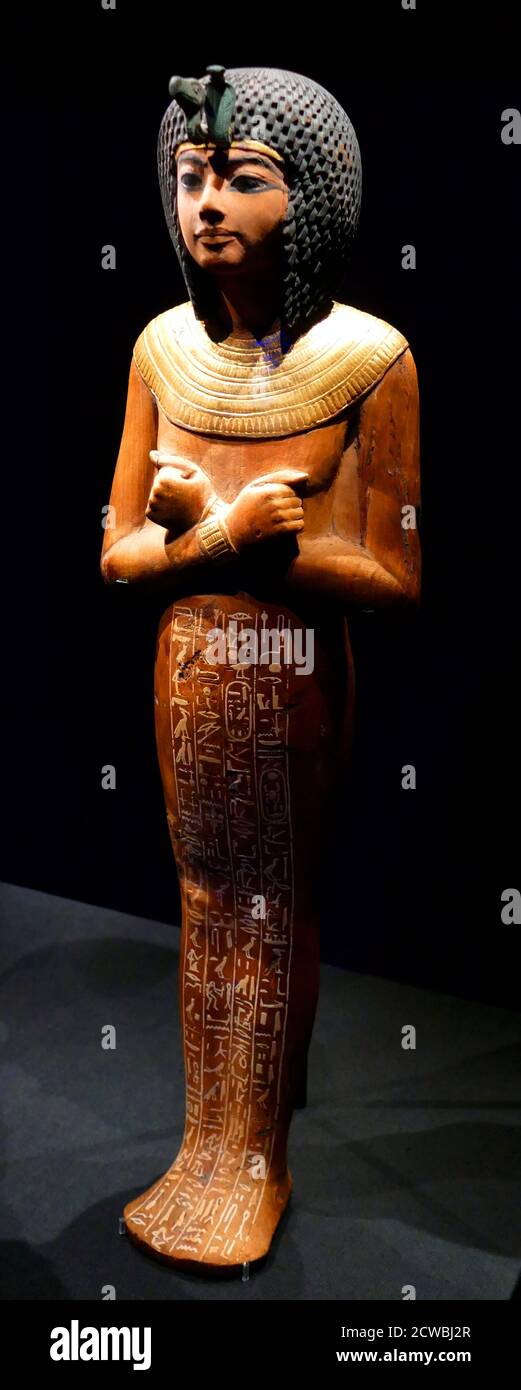 painted wooden Shabti figure, with ebony Nubian wig, bronze uraeus and ...