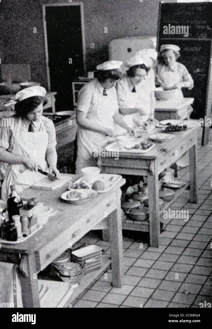 Photograph showing girls learning cookery in a domestic science class ...