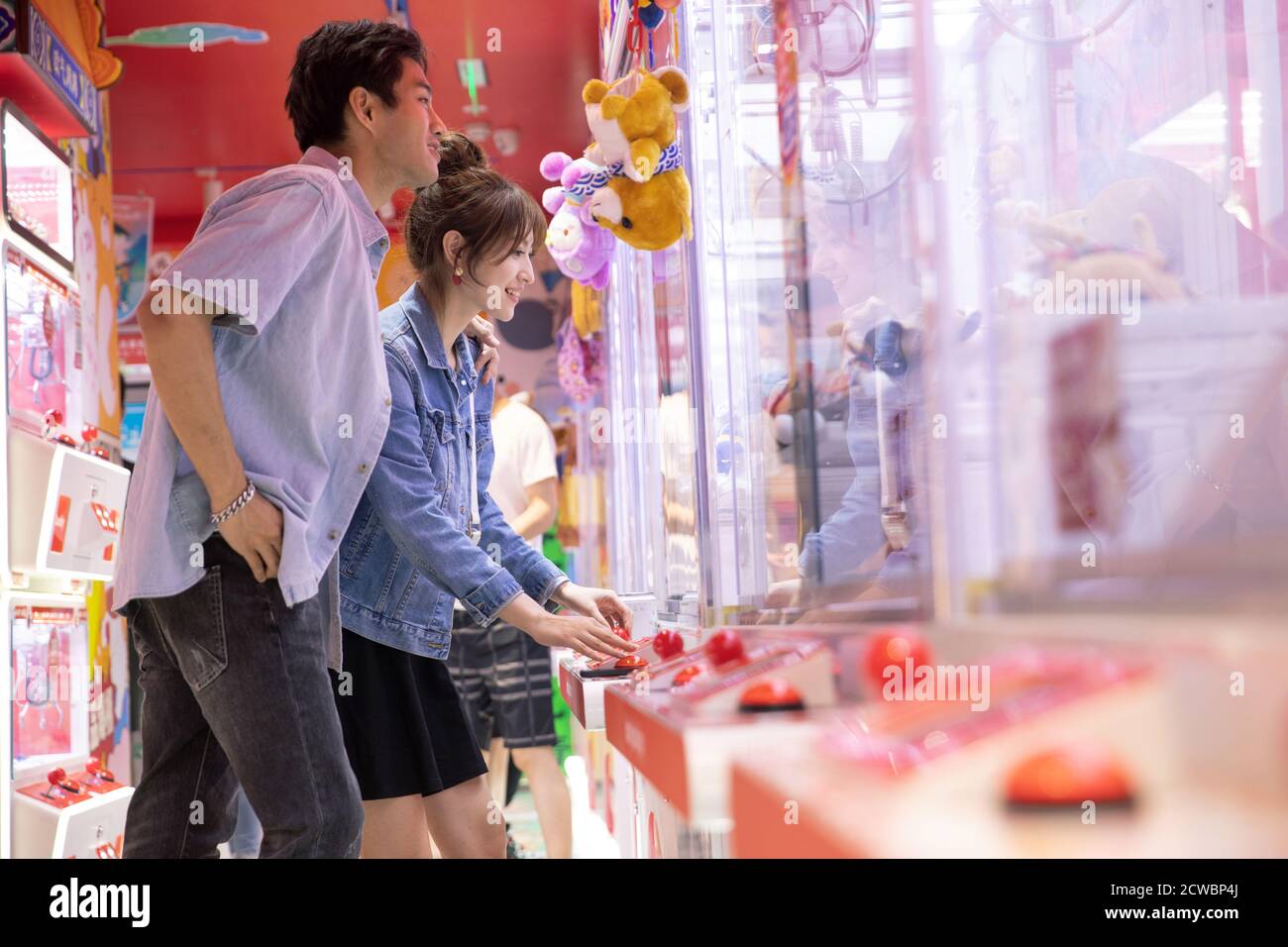 Happy couples playing catch a doll Stock Photo - Alamy