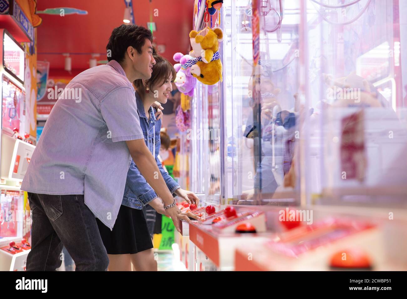 Happy couples playing catch a doll Stock Photo - Alamy