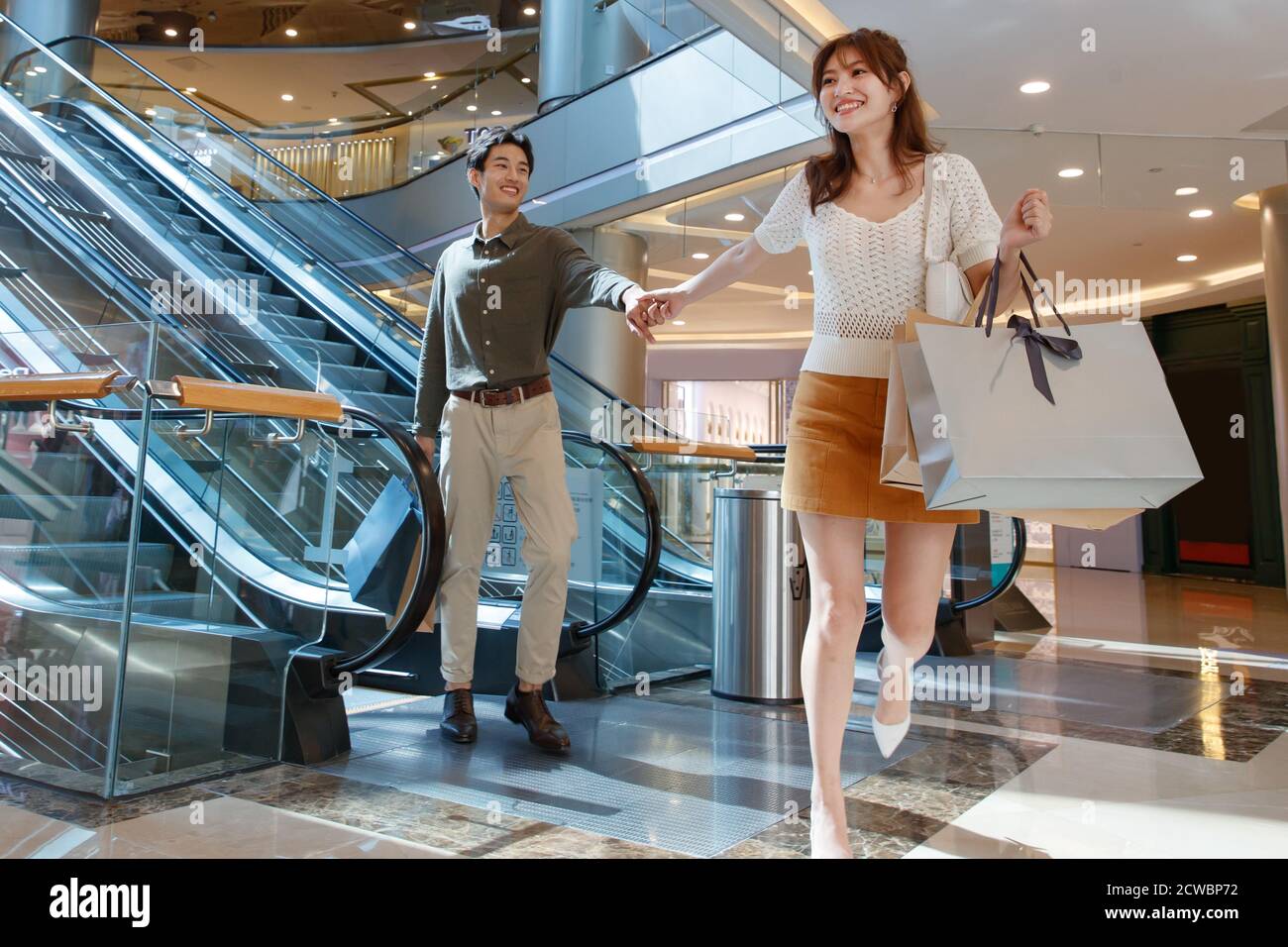 Young lovers hand in hand shopping at the mall Stock Photo - Alamy