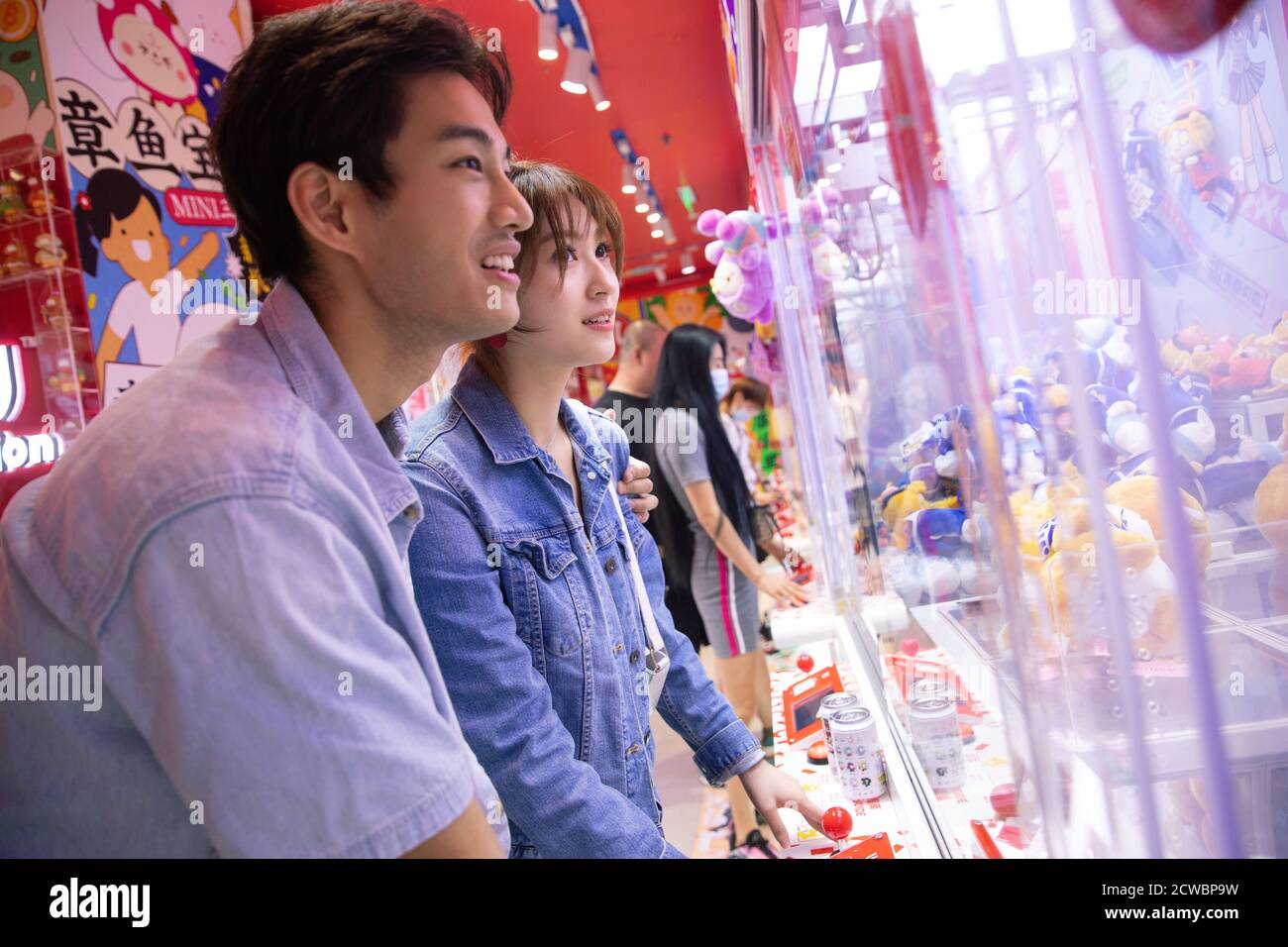 Happy couples playing catch a doll Stock Photo - Alamy