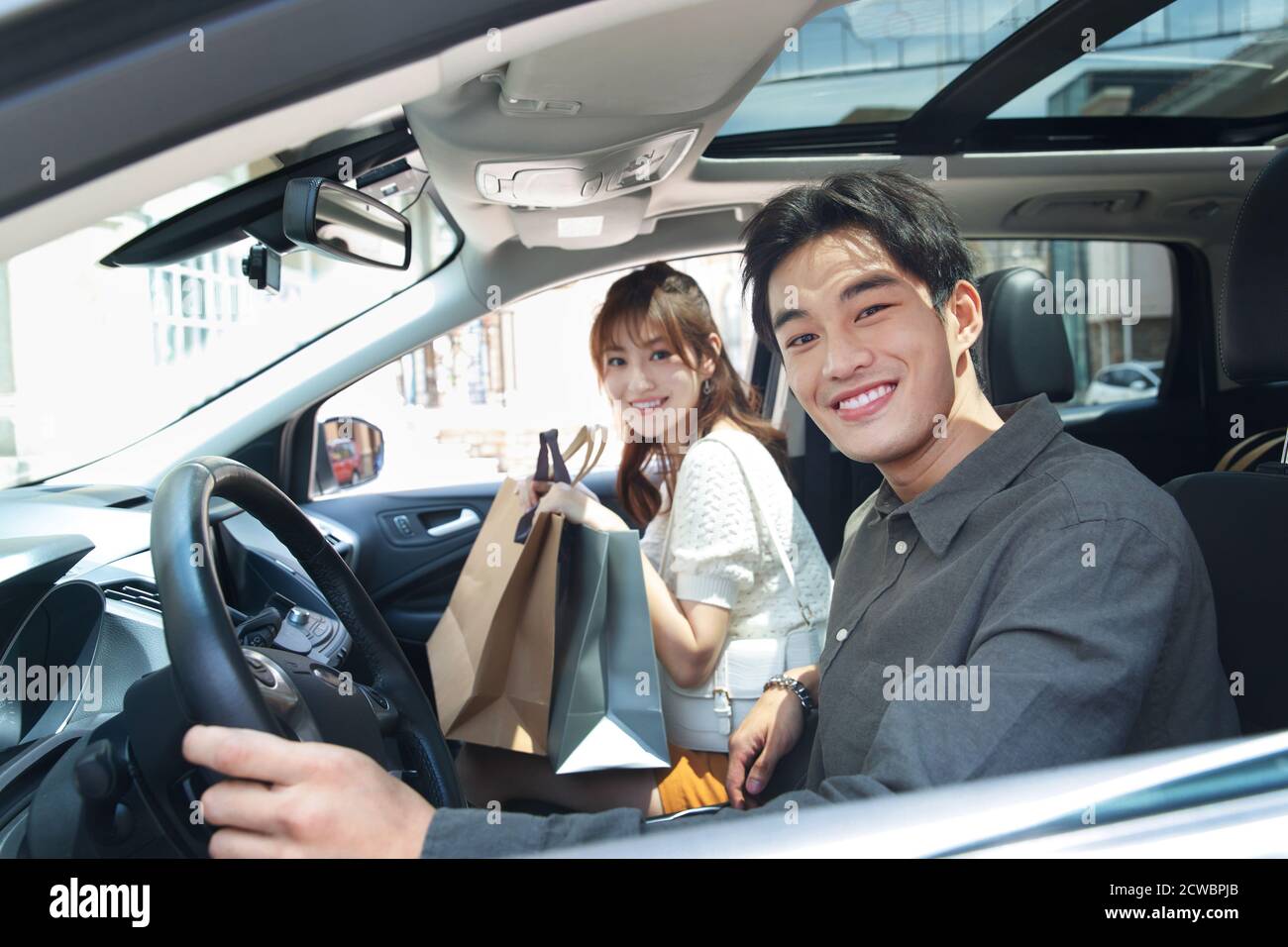 Happy couple sat in the car Stock Photo - Alamy