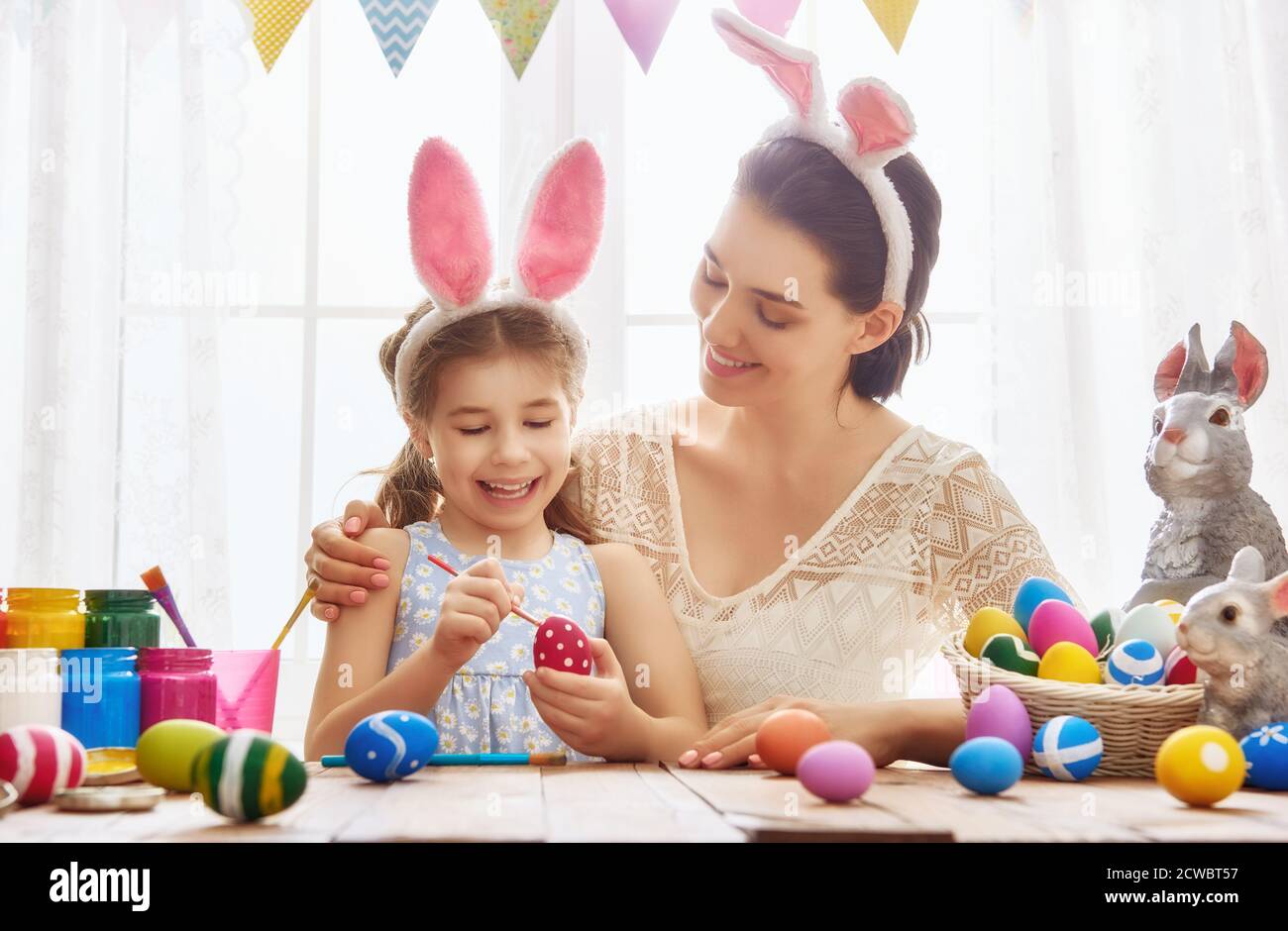 Happy easter! A mother and her daughter painting Easter eggs. Happy ...