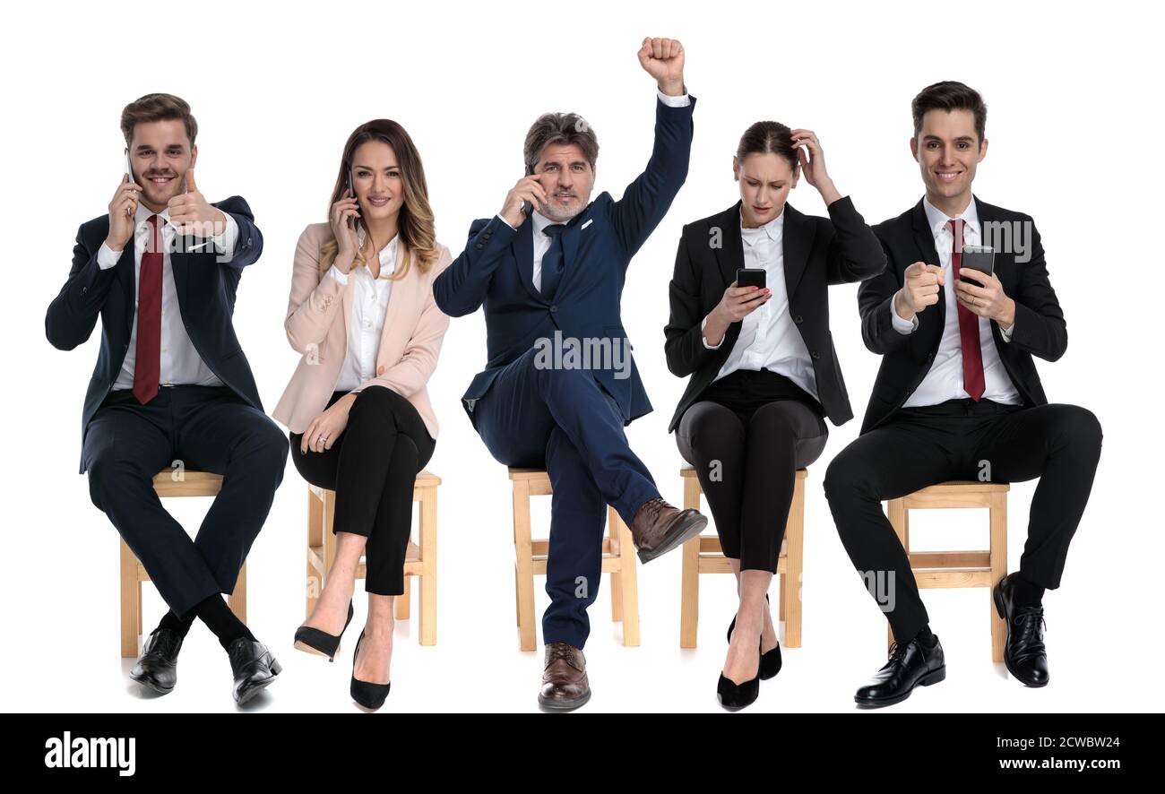 Team of 5 businessmen talking, reading and writing on their phones ...