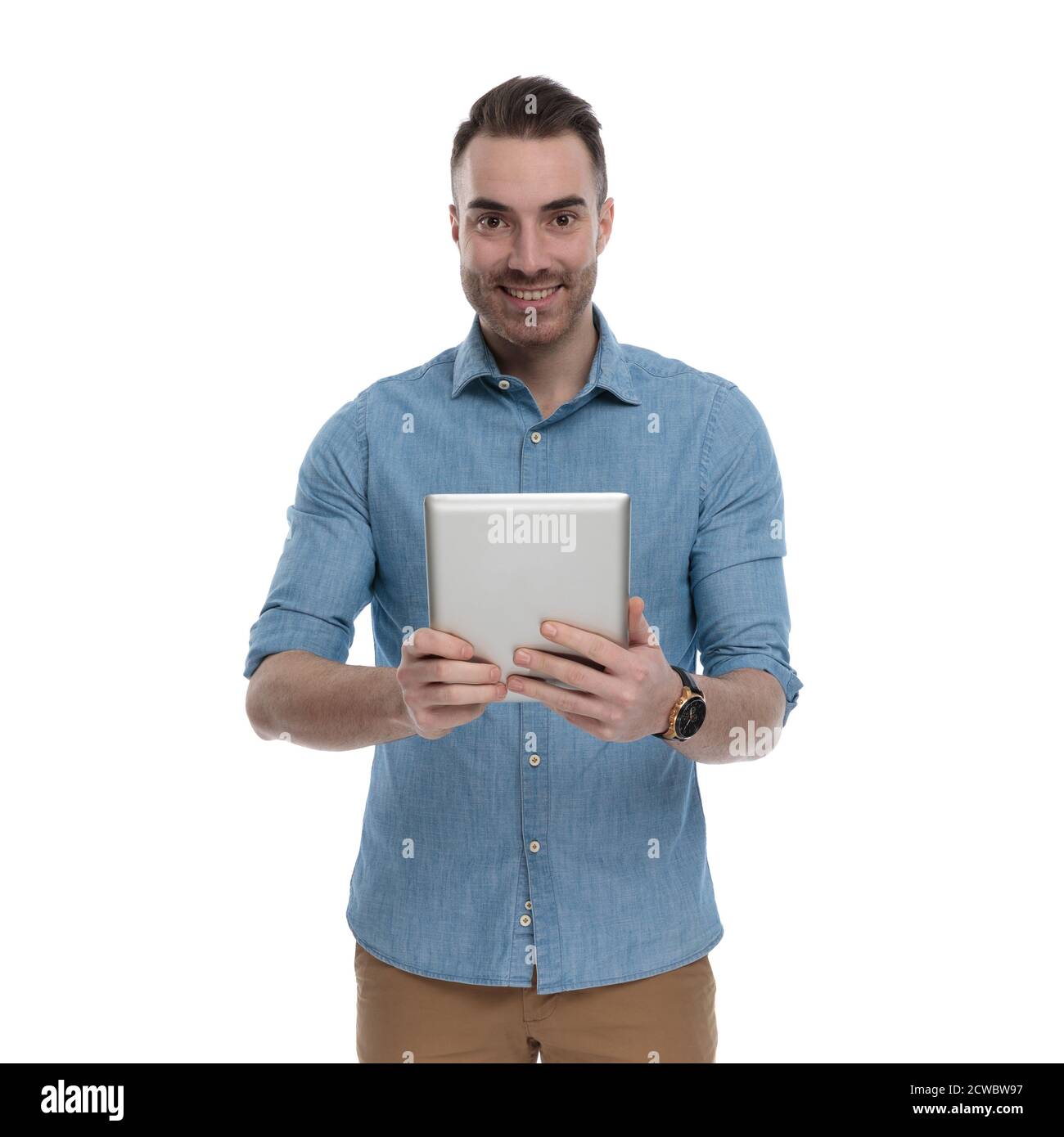 Happy casual man holding tablet and smiling while wearing blue shirt ...