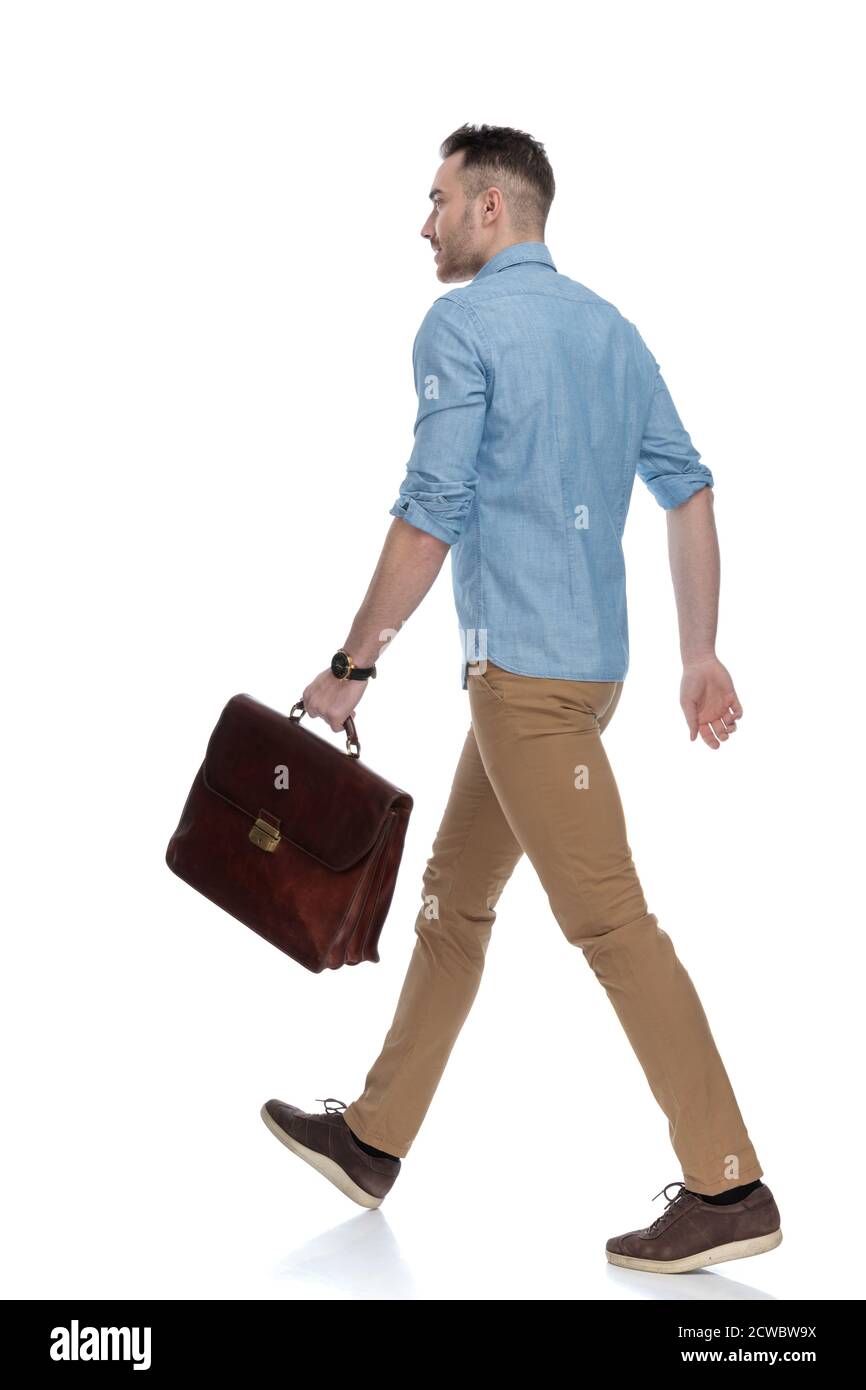 Side view of confident casual holding briefcase while wearing blue ...