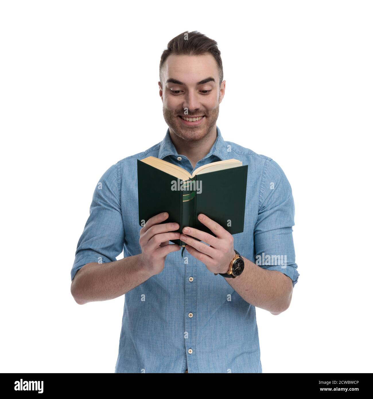 Handsome casual reading book and smiling while wearing blue shirt ...