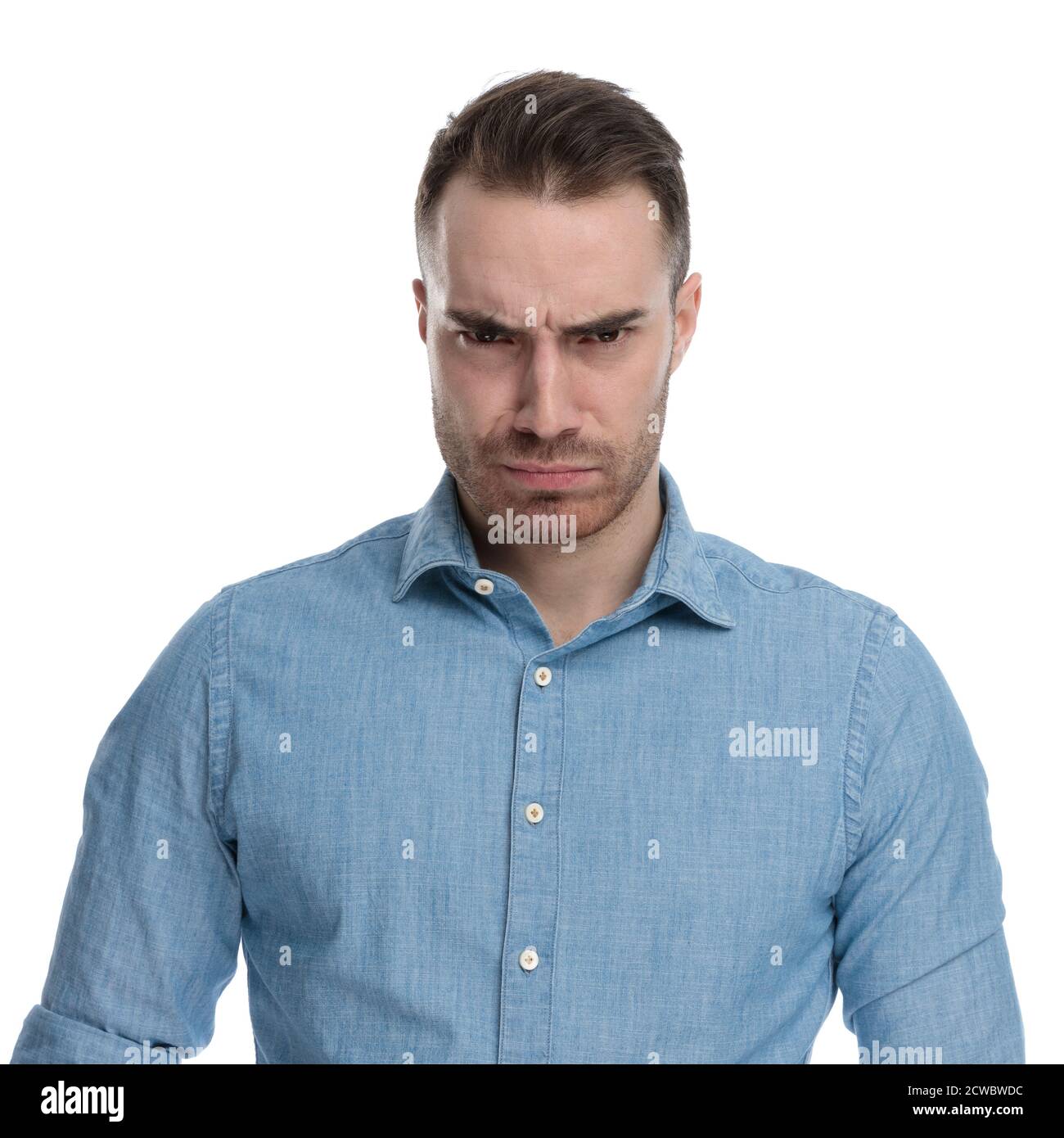 Bothered casual man looking forward and frowning while wearing blue ...