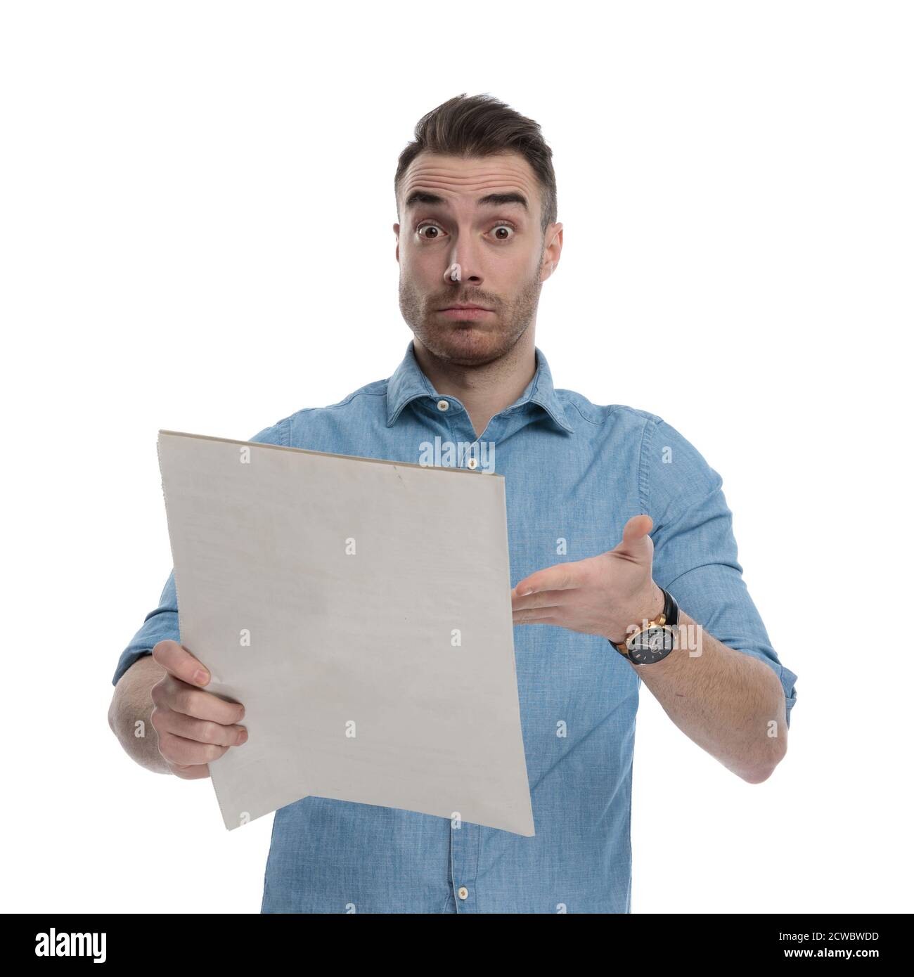 Bothered casual man reading and pointing at newspaper while wearing ...