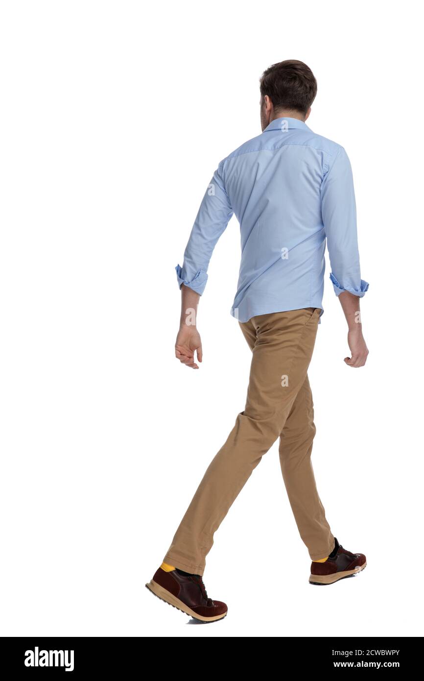 Side-rear view of casual man walking on white studio background Stock ...