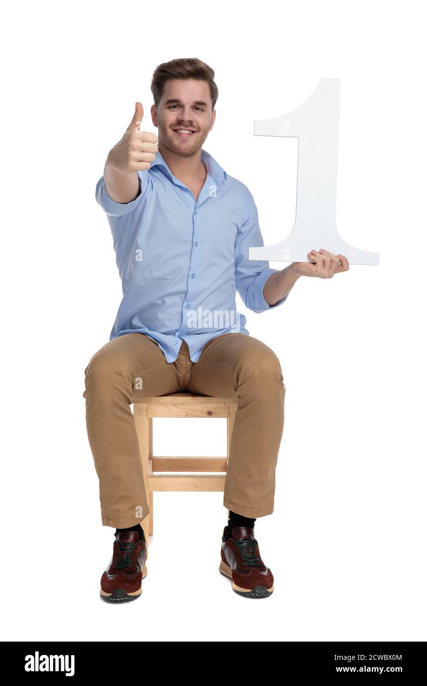 Positive casual man holding number one and gesturing okay while smiling ...