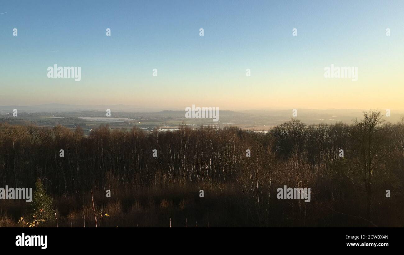 A pastel sunset over the countryside viewed from a forest look out ...