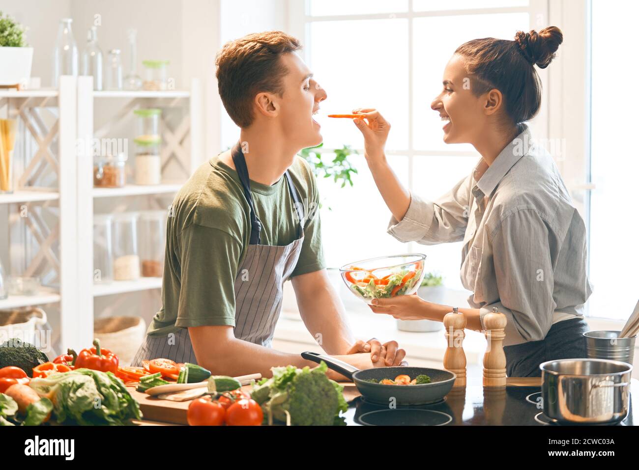 Healthy food at home. Happy loving couple is preparing the proper meal ...