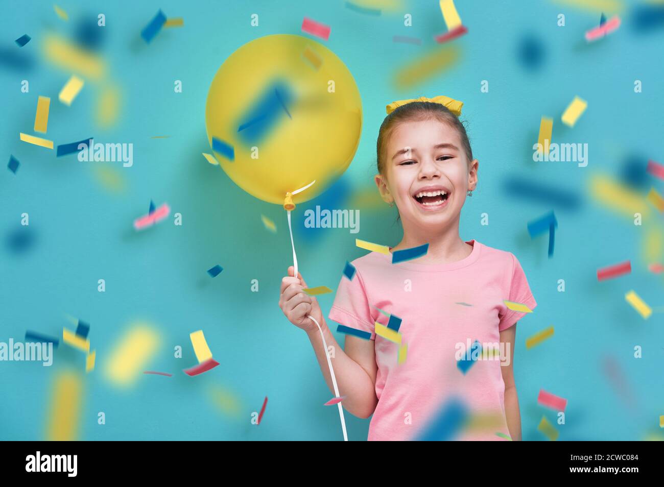 Funny child on a background of bright blue wall. Girl is having fun ...