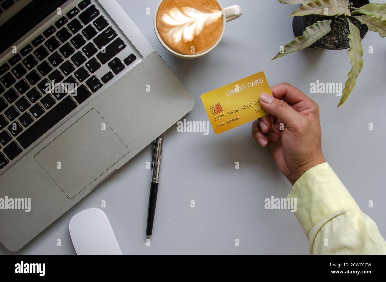 Top view man holding a credit card and on the desk. Laptop computer ...