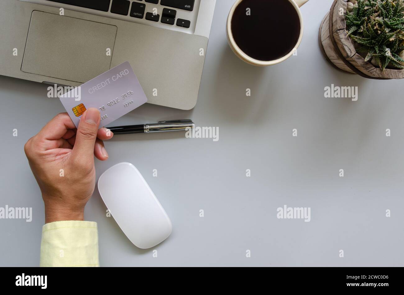 Top view man holding a credit card and on the desk. Laptop computer ...