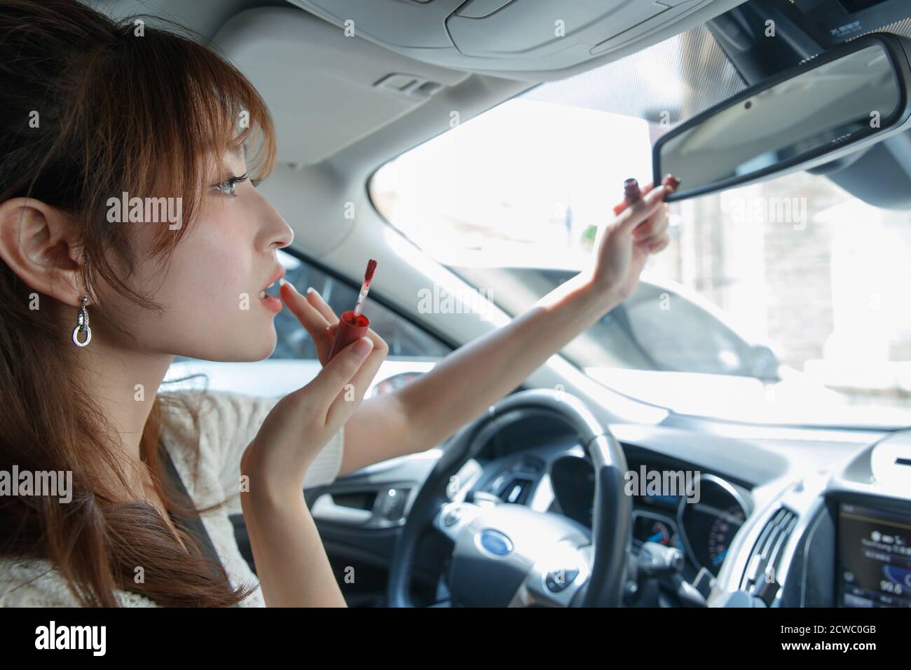 Young woman makeup in the car Stock Photo - Alamy