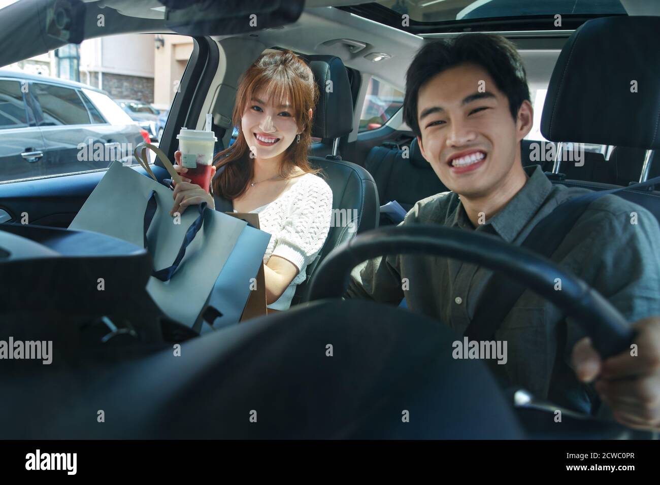 Happy couple sat in the car Stock Photo - Alamy