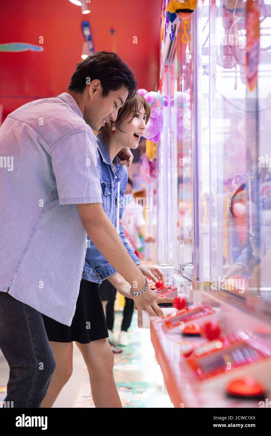 Happy couples playing catch a doll Stock Photo - Alamy