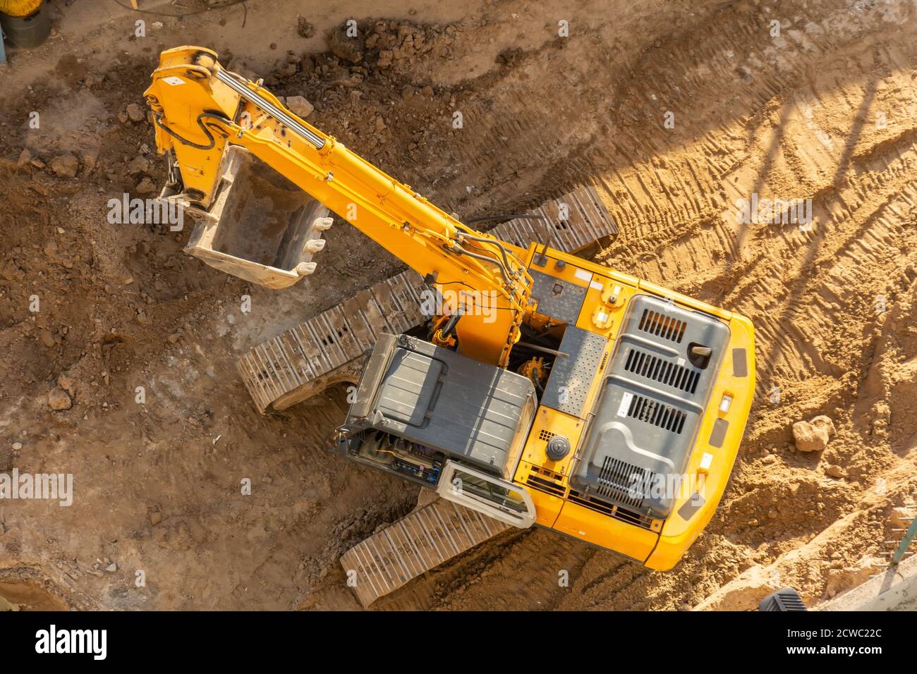 Excavator on the ground of a construction site with a raised bucket ...