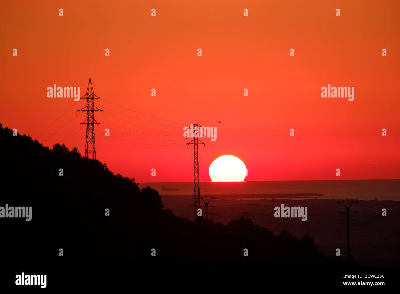 Beautiful shot of hills and transmission towers under the red sky during sunset Stock Photo - Alamy