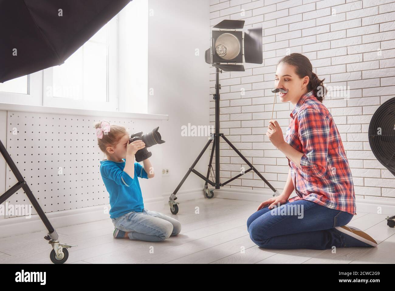 Photographer in motion. Young woman photographer and child girl having ...