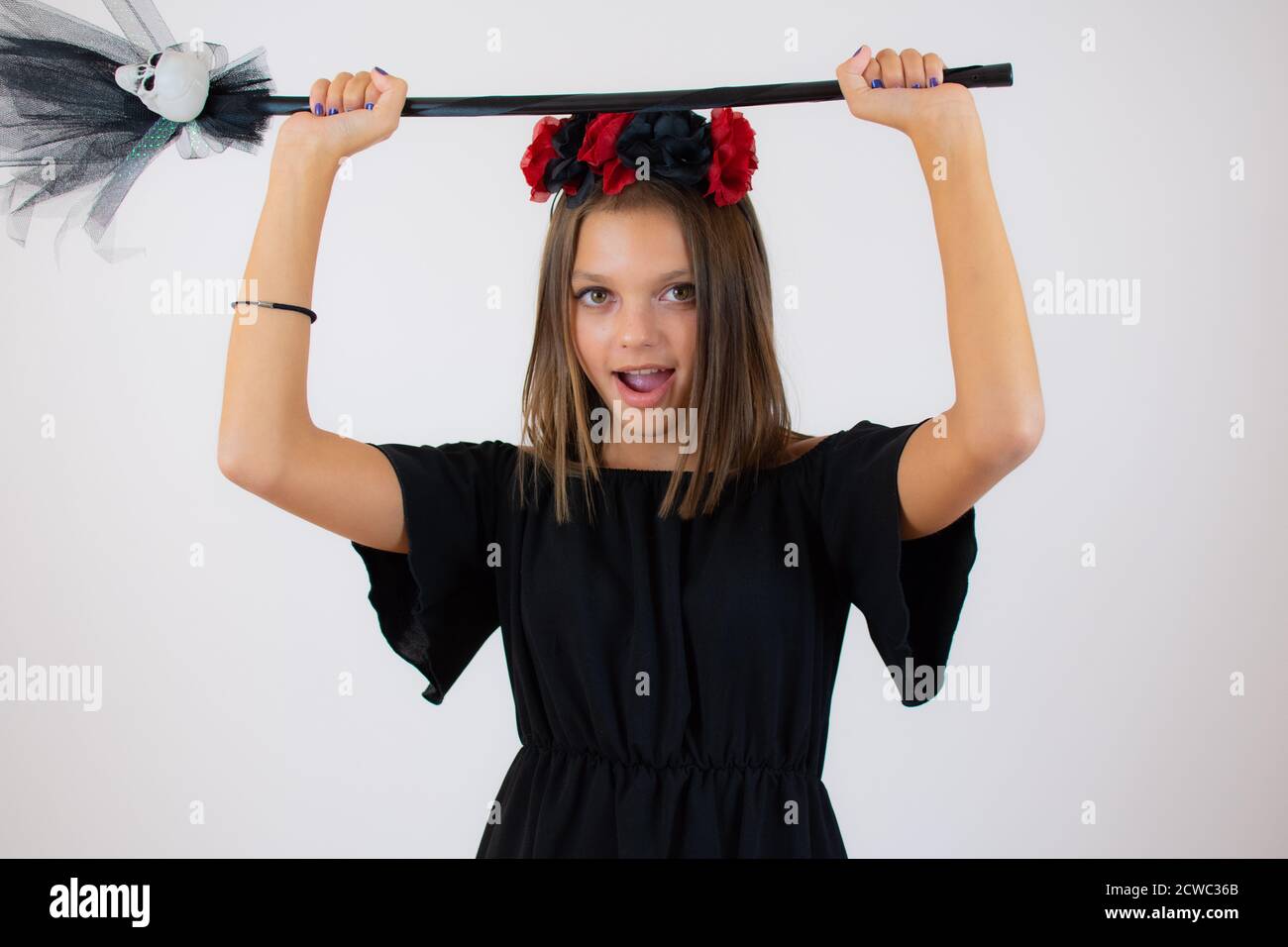 Image of nice girl in black halloween costume looking at camera and ...